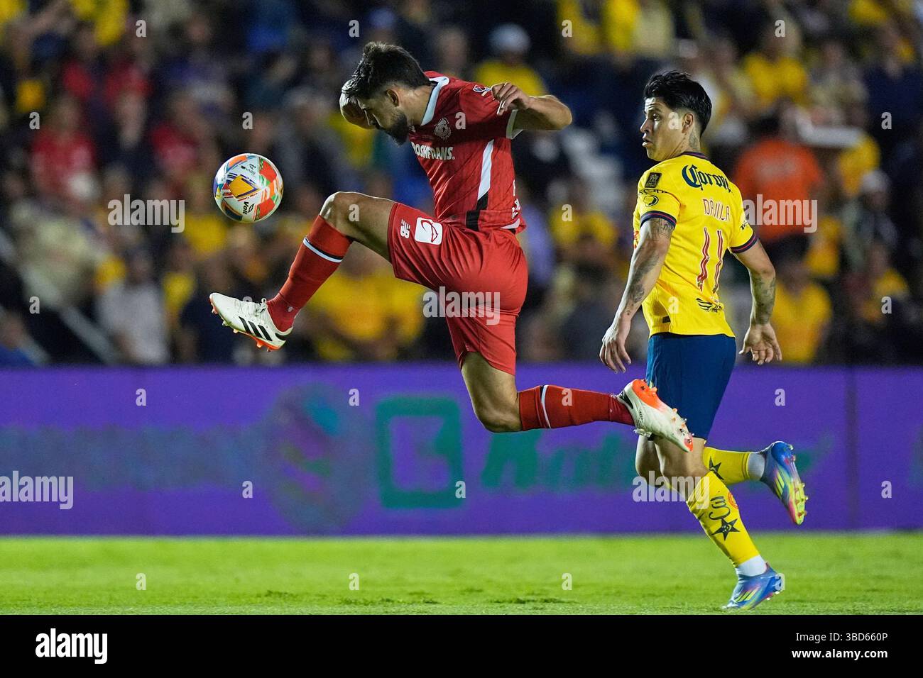 Toluca's Bruno Mendez, left, tries controls the ball past America's ...