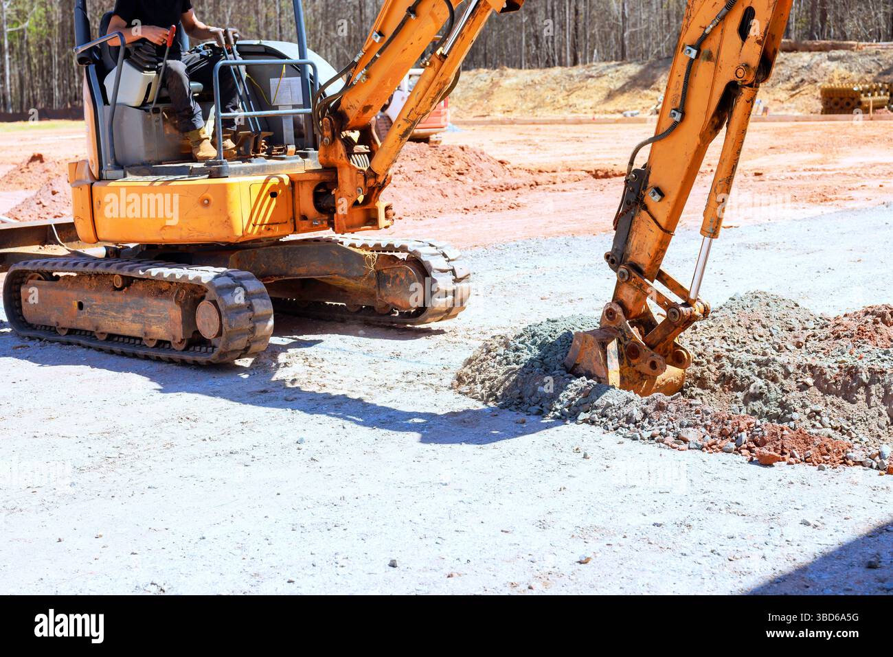 Heavy machinery operates on construction site, digging gravel as work ...