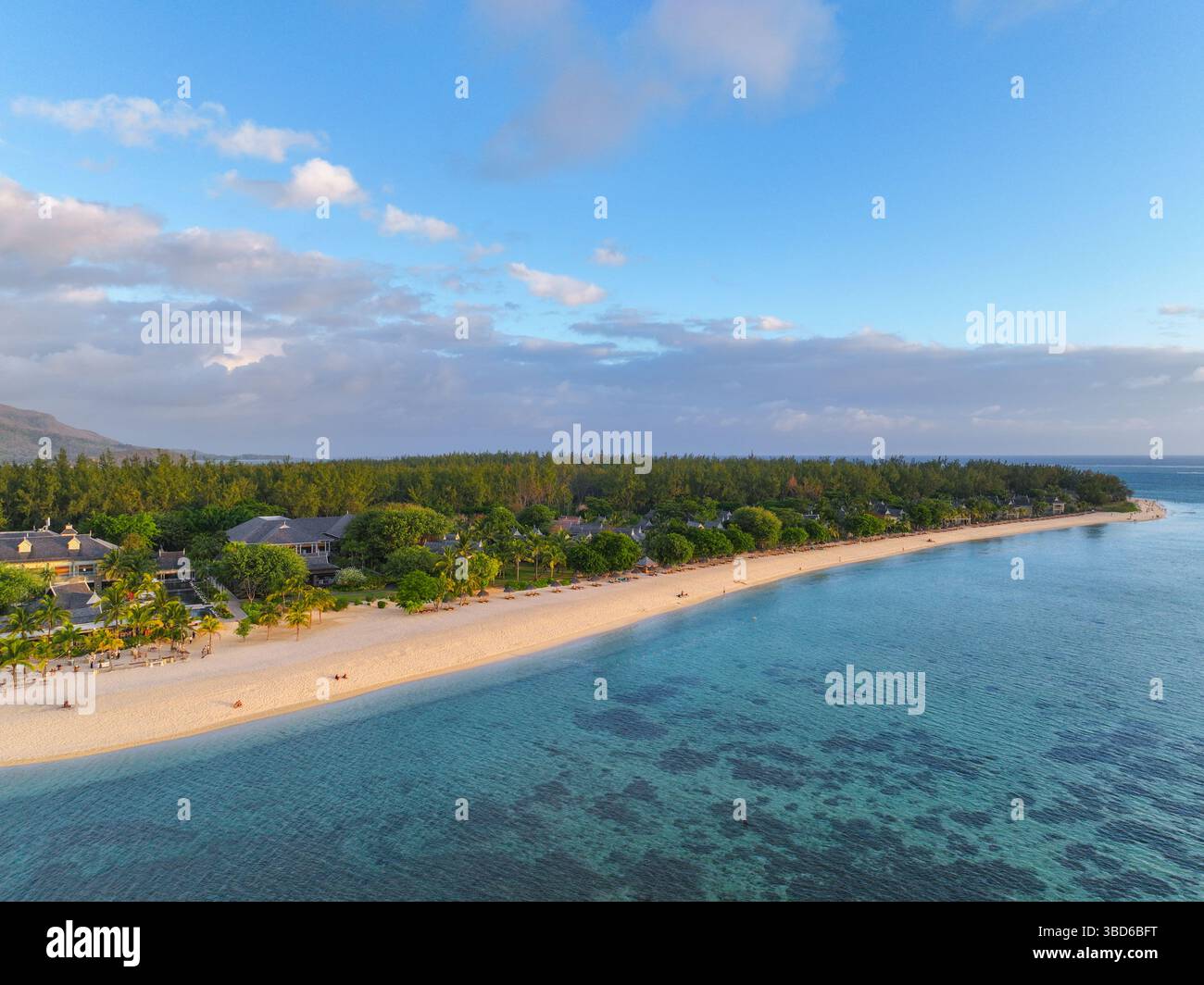 The coastline of Le Morne, Mauritius curves along calm turquoise waters ...