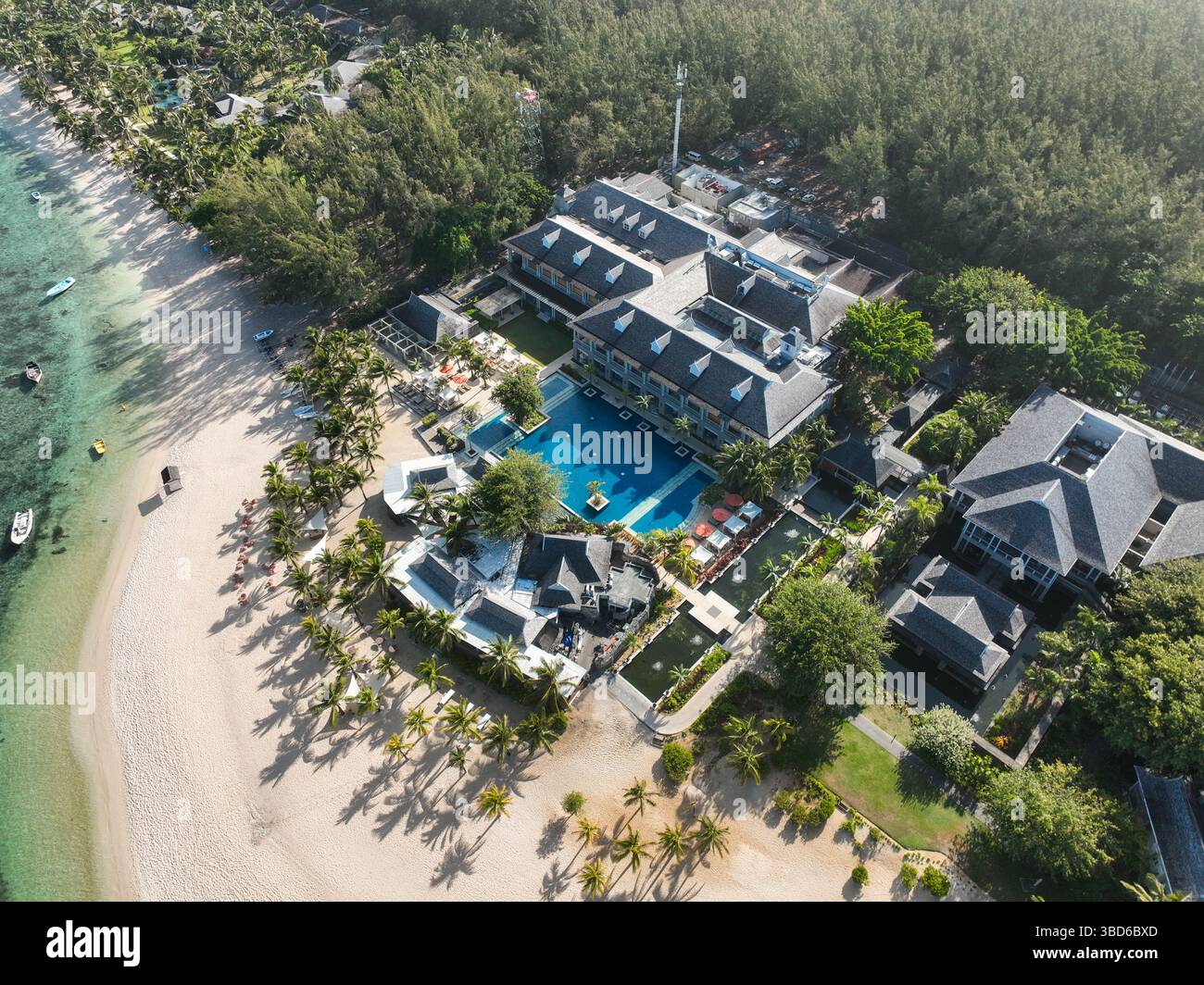 Drone view of luxury resort with beachfront pool and palm trees in ...