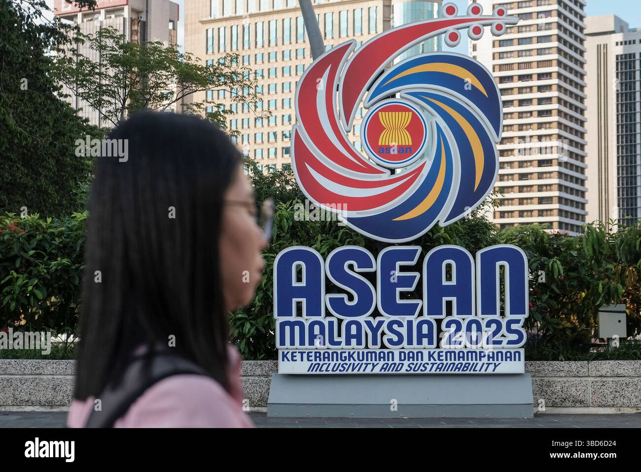A woman seen passing by a decoration of the 46th ASEAN Summit displayed on a huge billboard ...