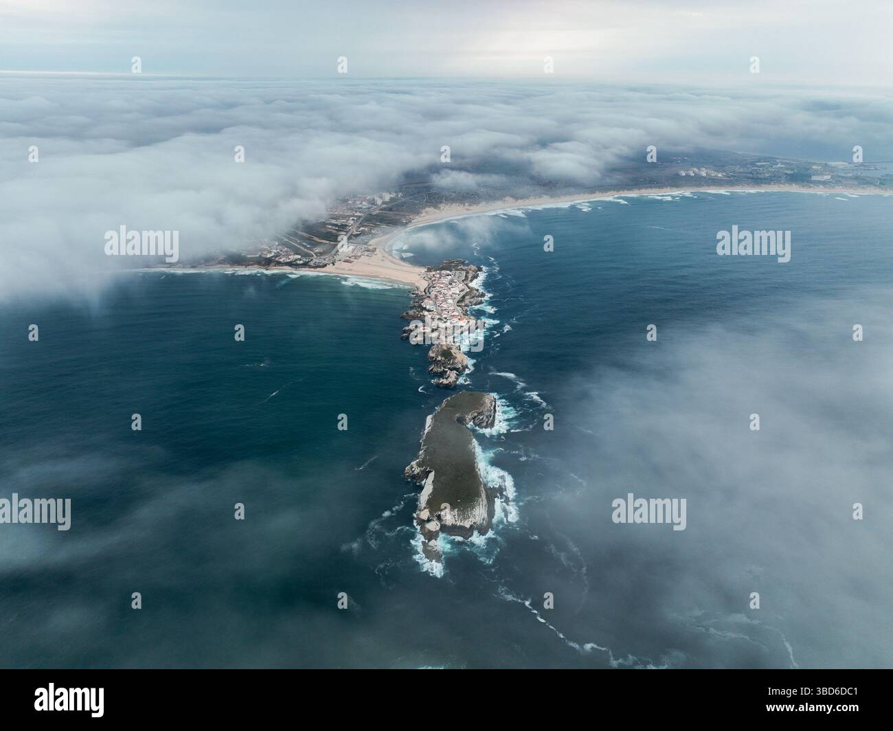 Aerial view of Baleal town and cliffs under cloudy skies across open ...