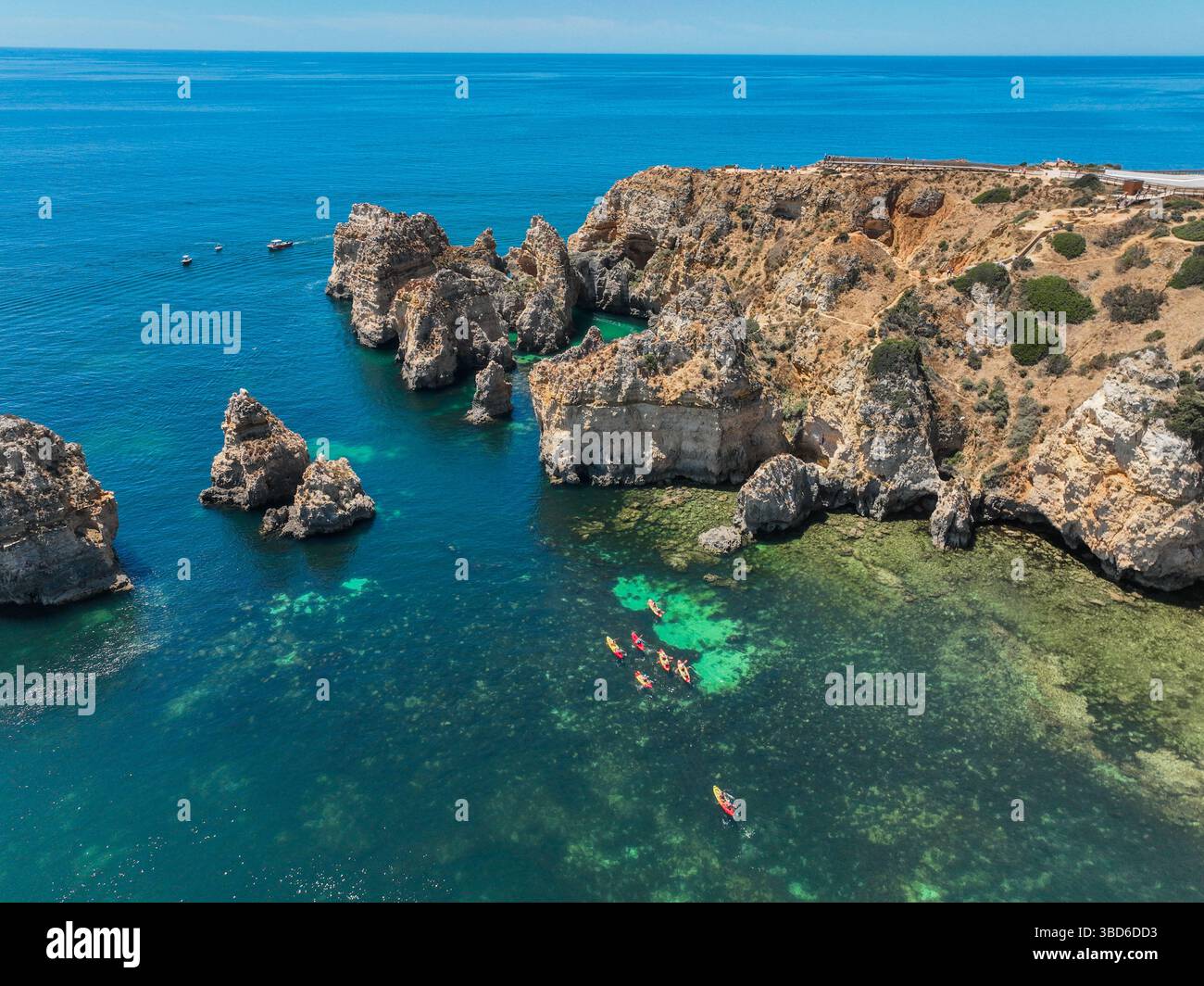 Aerial of kayakers paddling near cliffs and caves at Ponta da Piedade ...