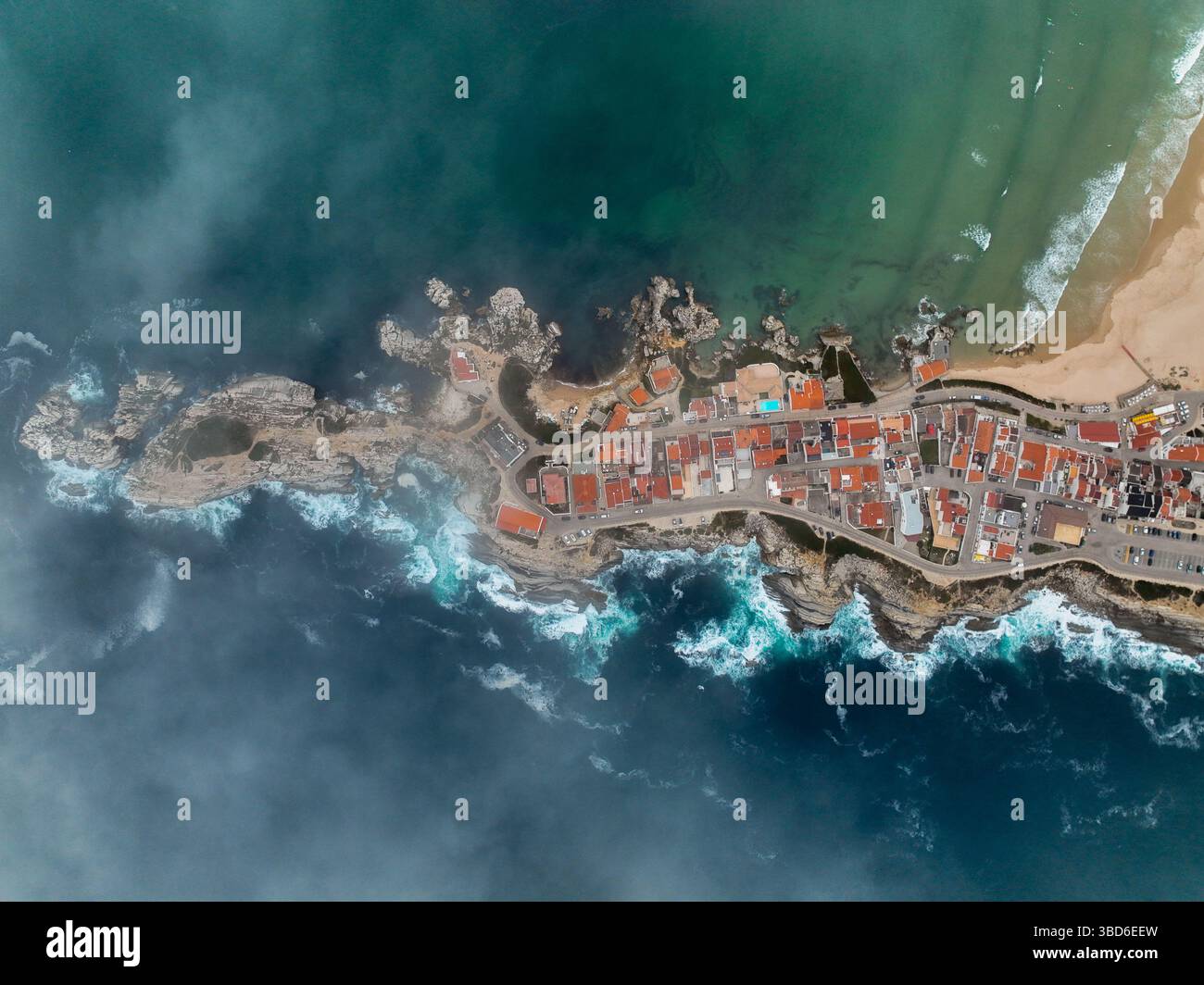 Direct overhead drone image of Baleal village and cliffs meeting rough ...