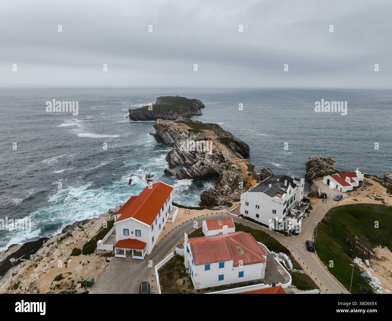 Drone image showing town buildings and rocky cliff trail to offshore ...