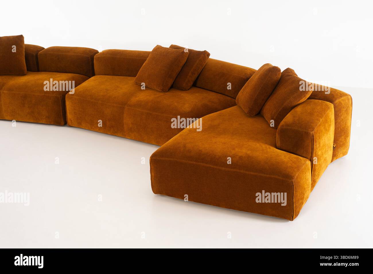 captures a modern modular sofa in golden brown velvet fabric, adorned ...