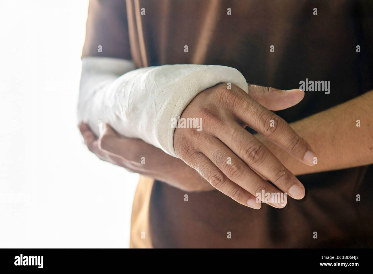 A close-up shot of a person's arm encased in a white plaster cast ...