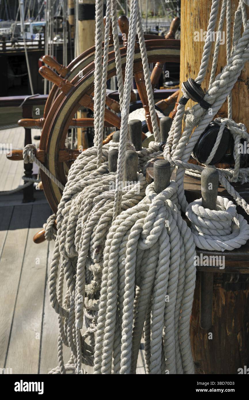 Steering wheel and ropes coiled around belaying pins aboard the Grand ...