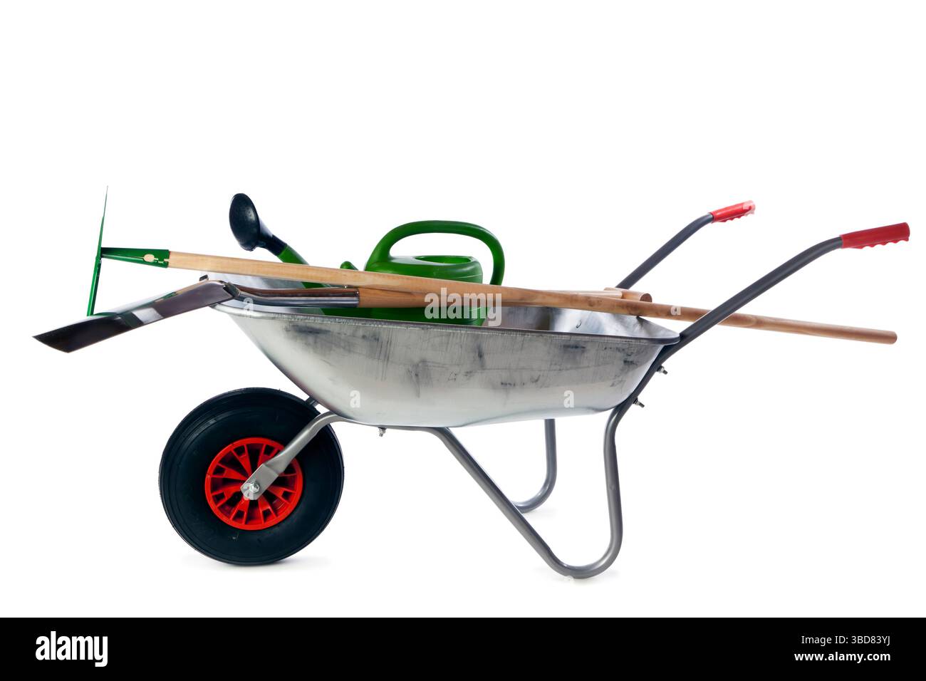 Spade, watering can and garden hoe in wheelbarrow isolated on white ...