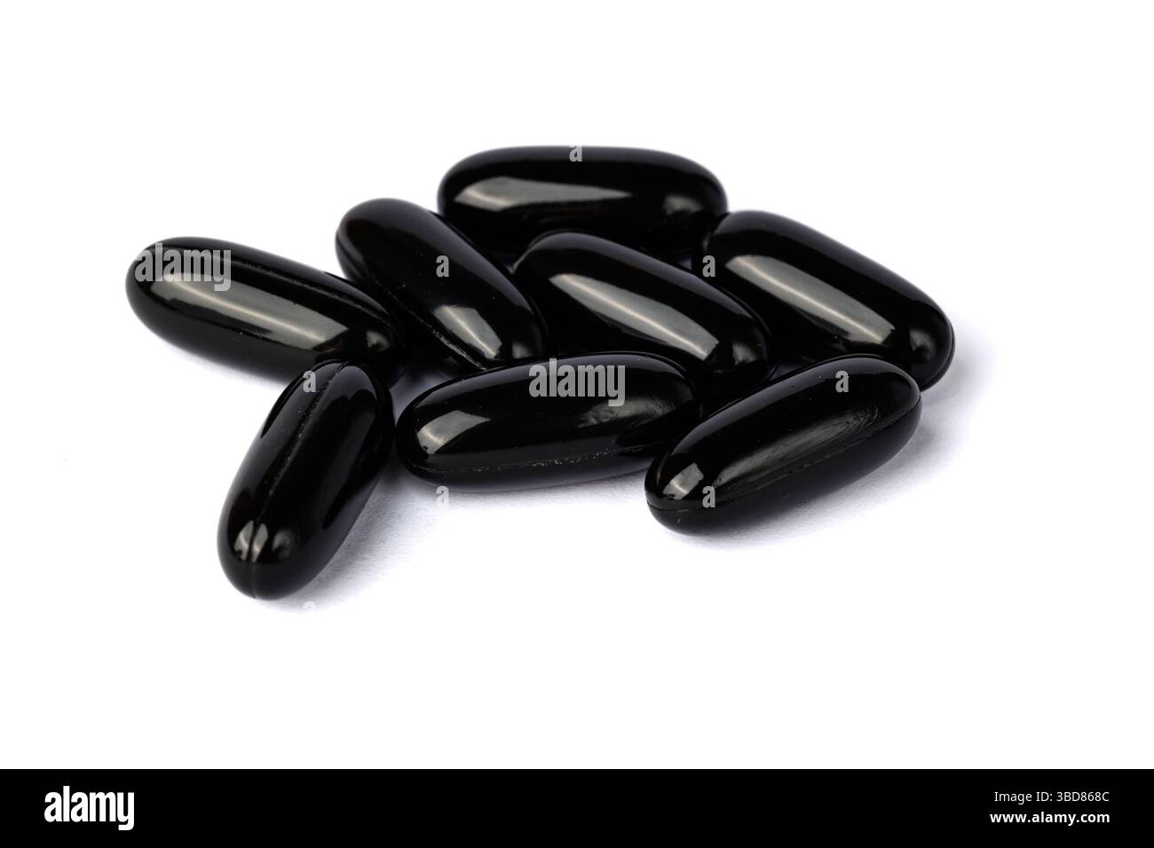 Black softgel capsules on white background Stock Photo - Alamy
