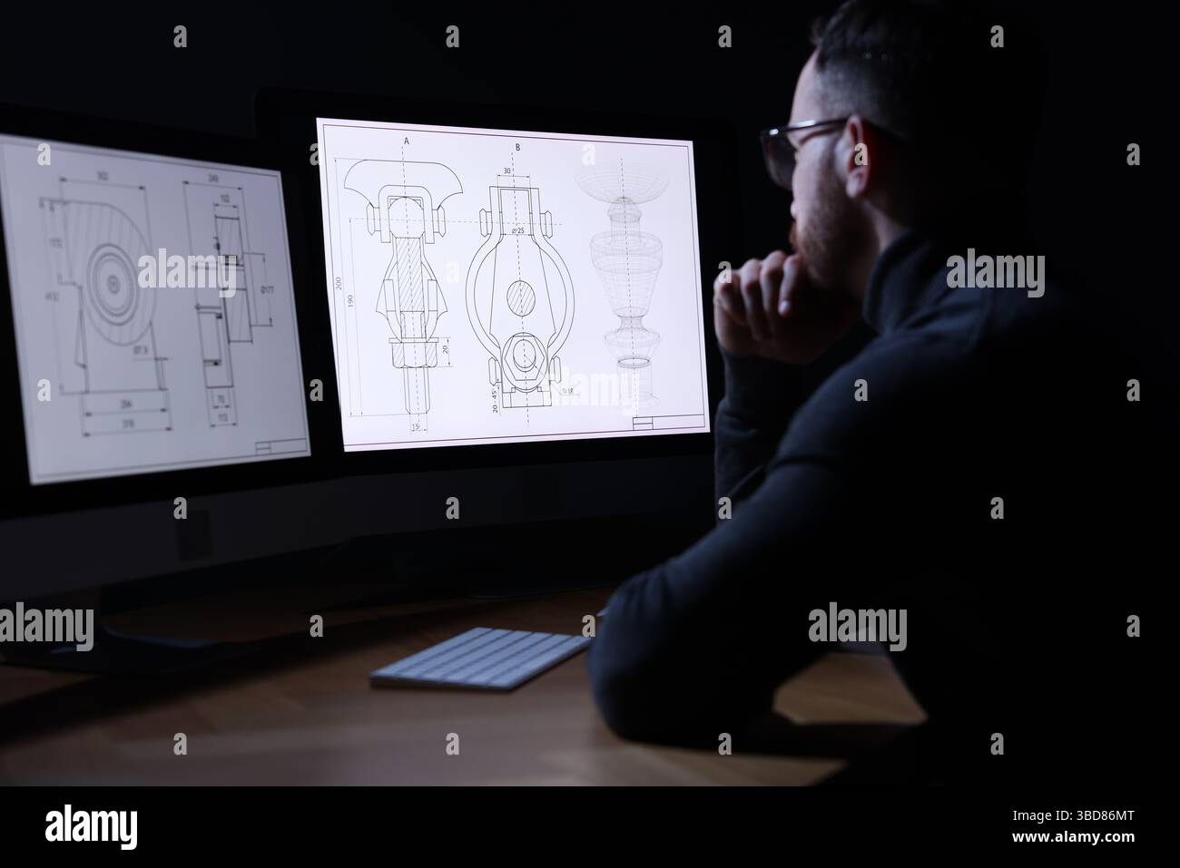Engineer working with digital drawings at table in office Stock Photo ...