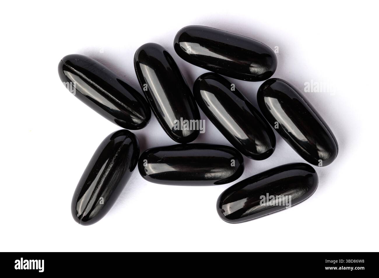 Black softgel capsules on white background Stock Photo - Alamy