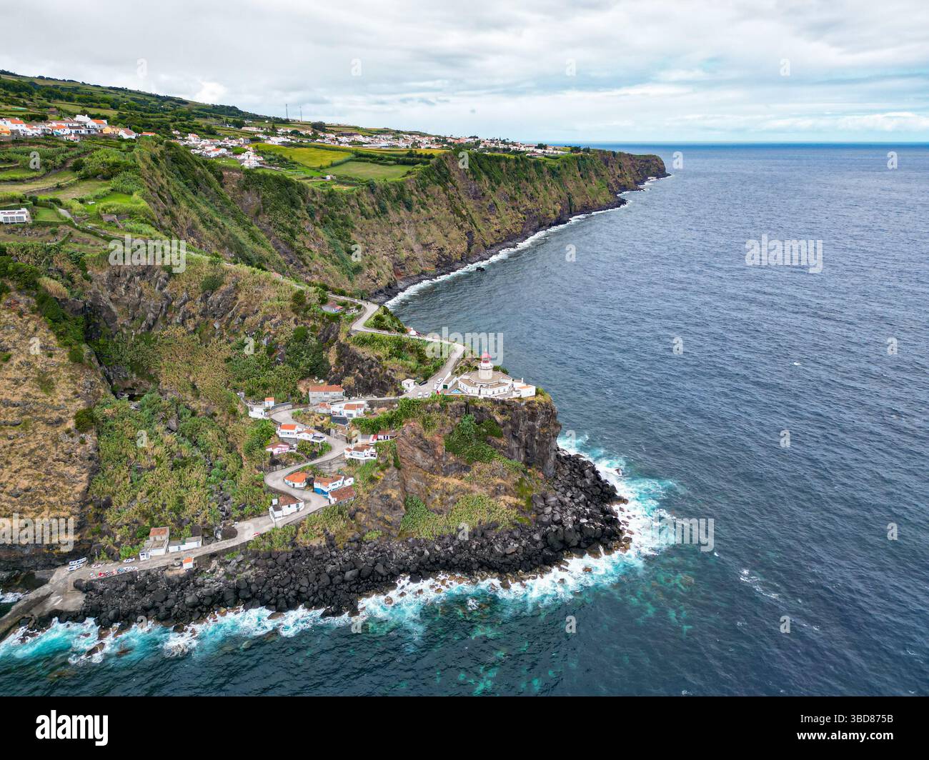 Aerial coastal view of Farol do Arnel lighthouse and fishermen's huts ...