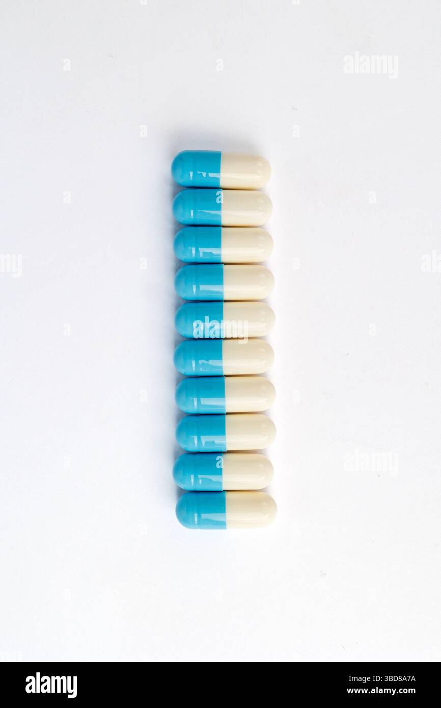 Blue and white medical capsules lined vertically Stock Photo - Alamy