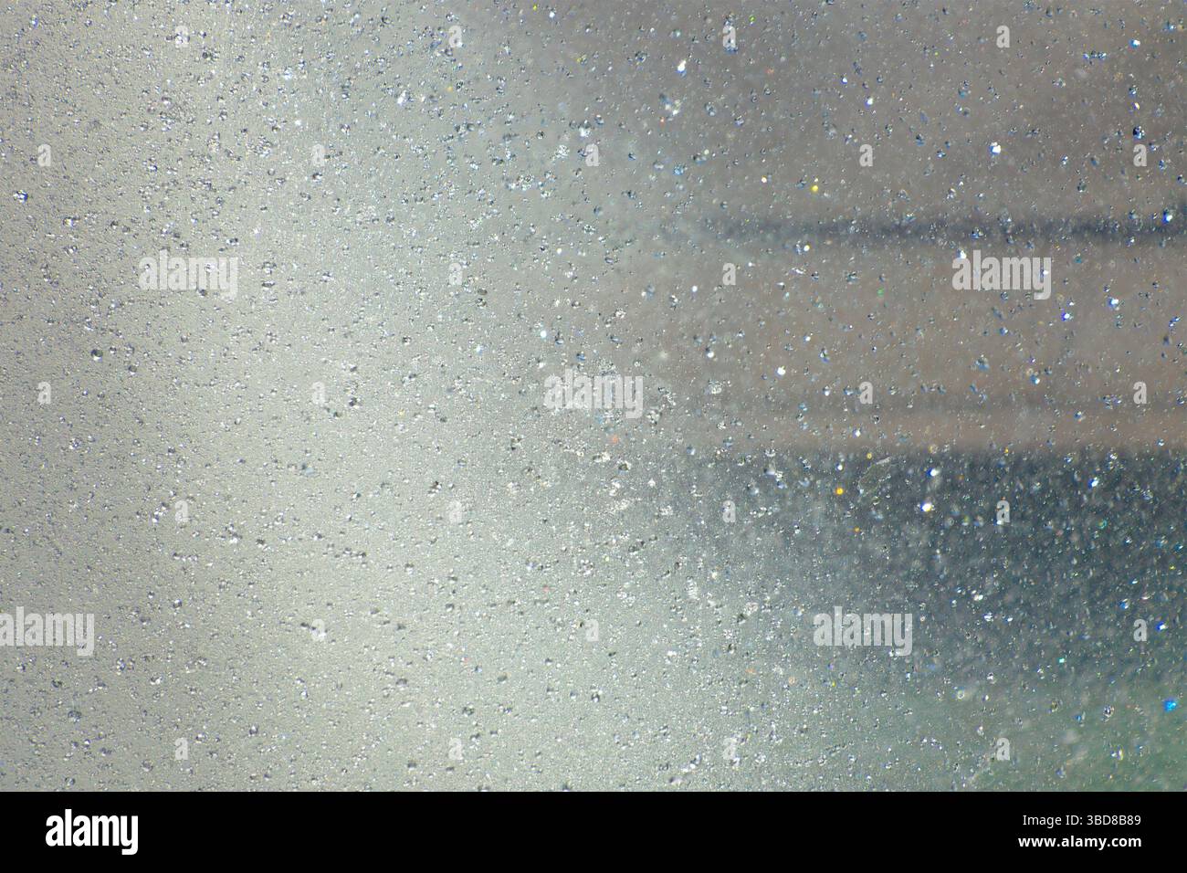 Water droplets in motion: clear liquid splash against neutral ...