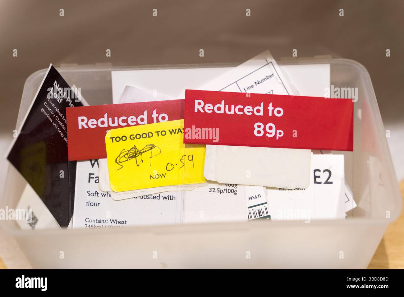 Plastic box filled with price reduction tags in red, yellow, white, and ...