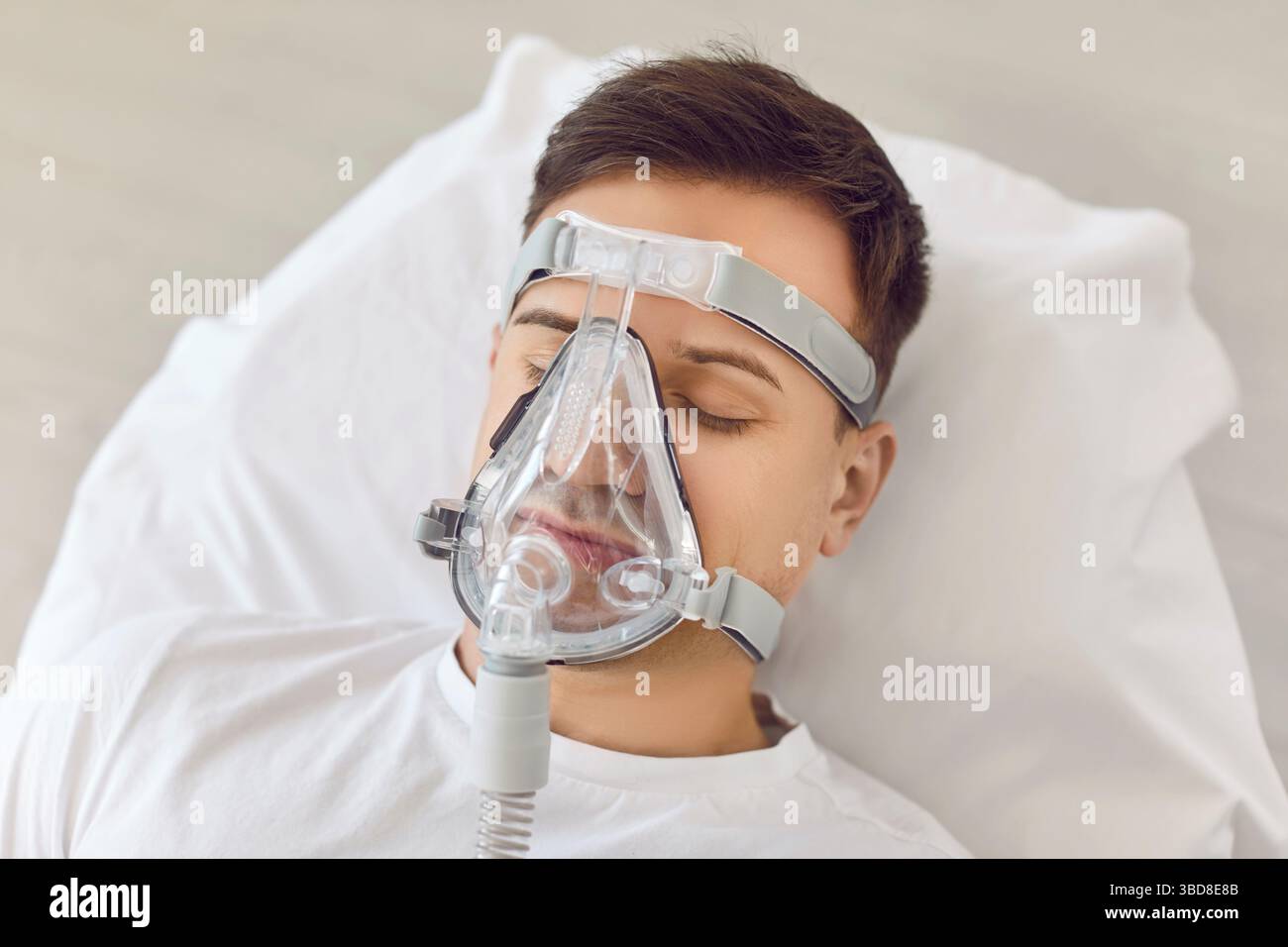 Male patient in aspirator sleeping on bed in coma in critical condition ...