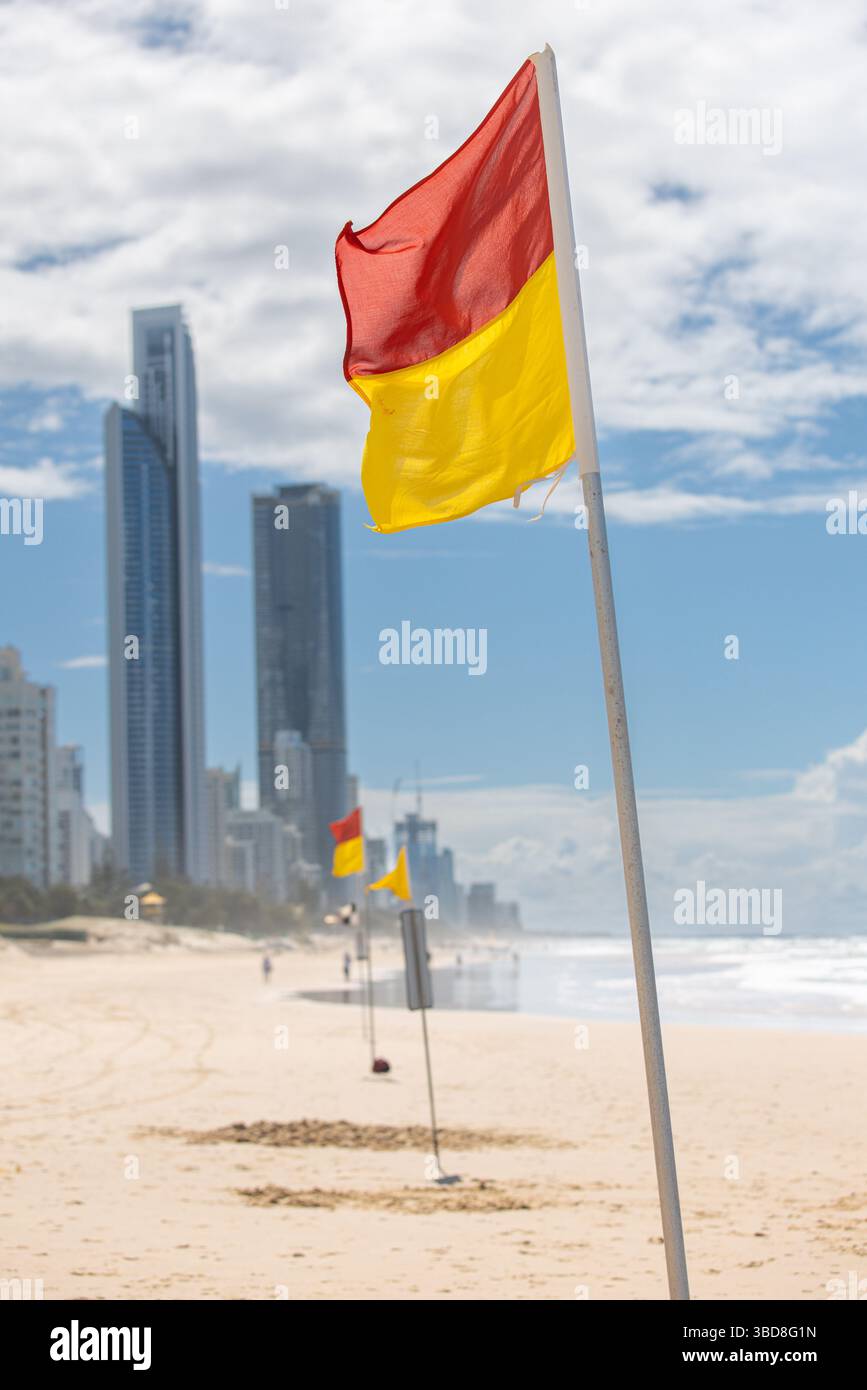 Red and yellow safety flags waving on sunny day on beach Gold Coast ...