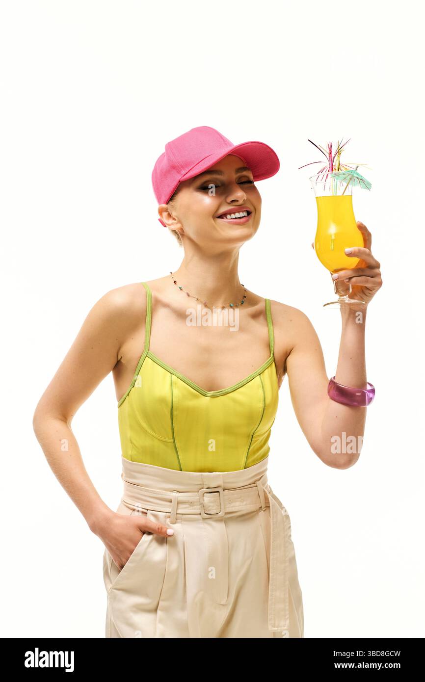 Brightly dressed woman smiles, holding a refreshing drink, exuding joy ...