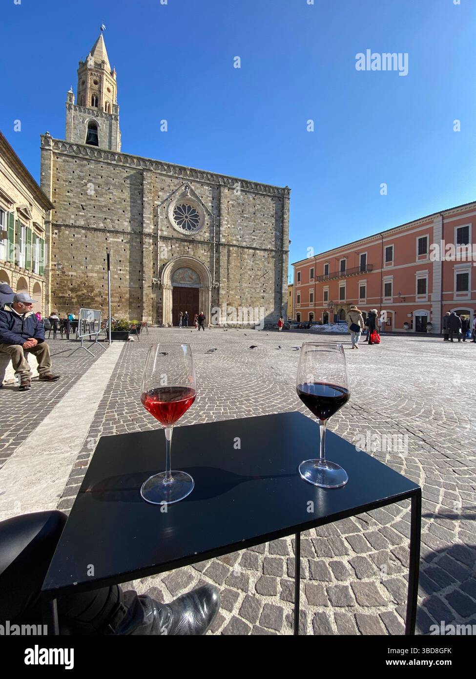 Wine glasses sitting on table near Atri Cathedral's facade, historic ...