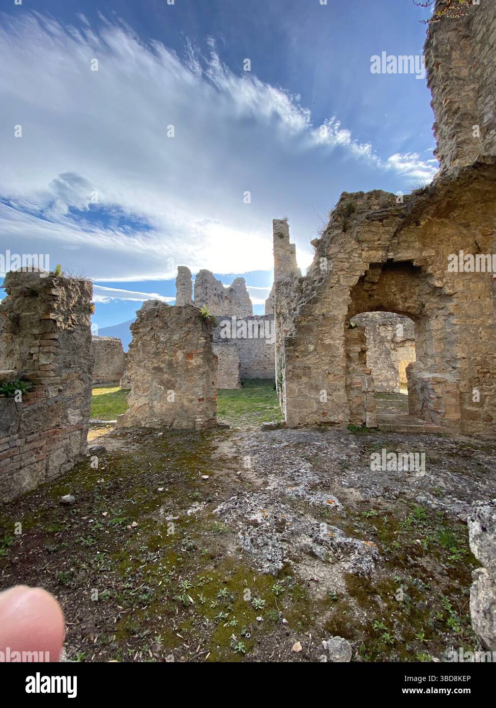 Crumbling walls and arches frame a view of the sky through the ruins of ...