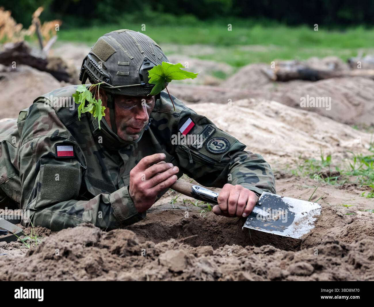 A candidate for Territorial Defence soldier digs in on a battle field ...
