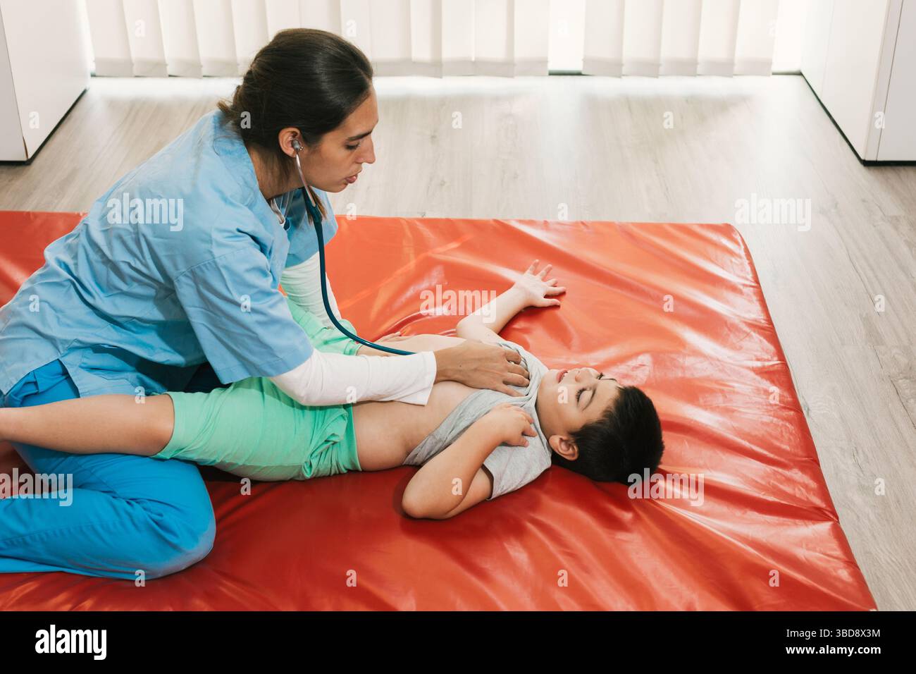 Respiratory physiotherapist examining child's lungs with stethoscope ...