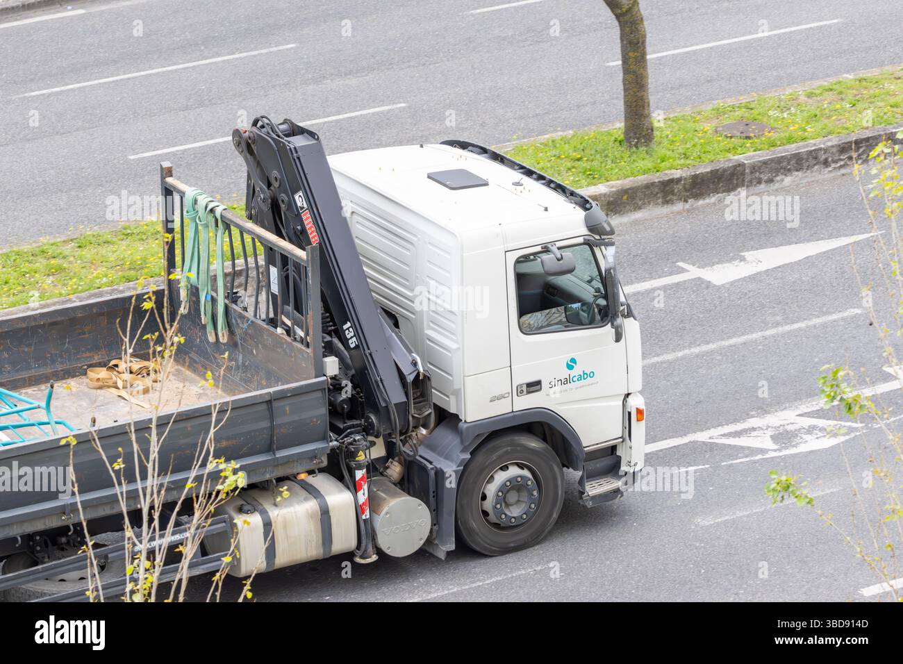 White crane truck parked on asphalt road near green grass, ready for ...