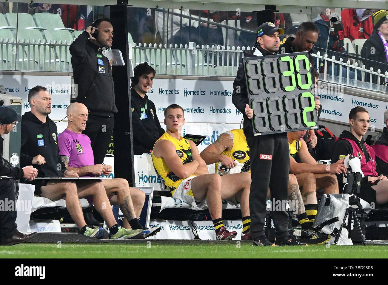 Sam Lalor of Richmond (centre) is seen along the interchange bench ...