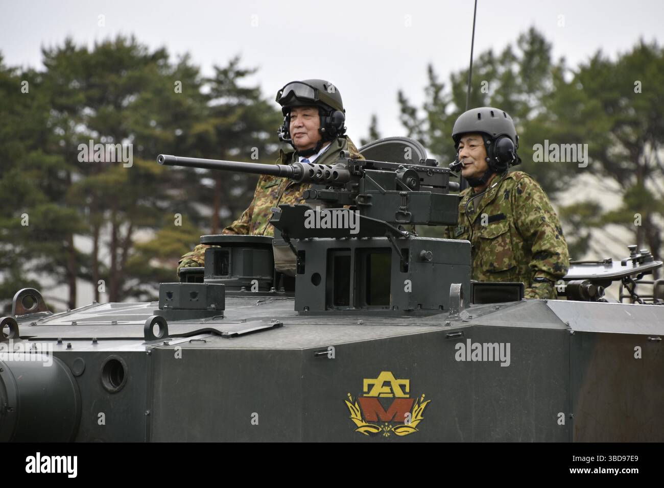 Japanese Defense Minister Gen Nakatani (L) rides a tank during a visit ...