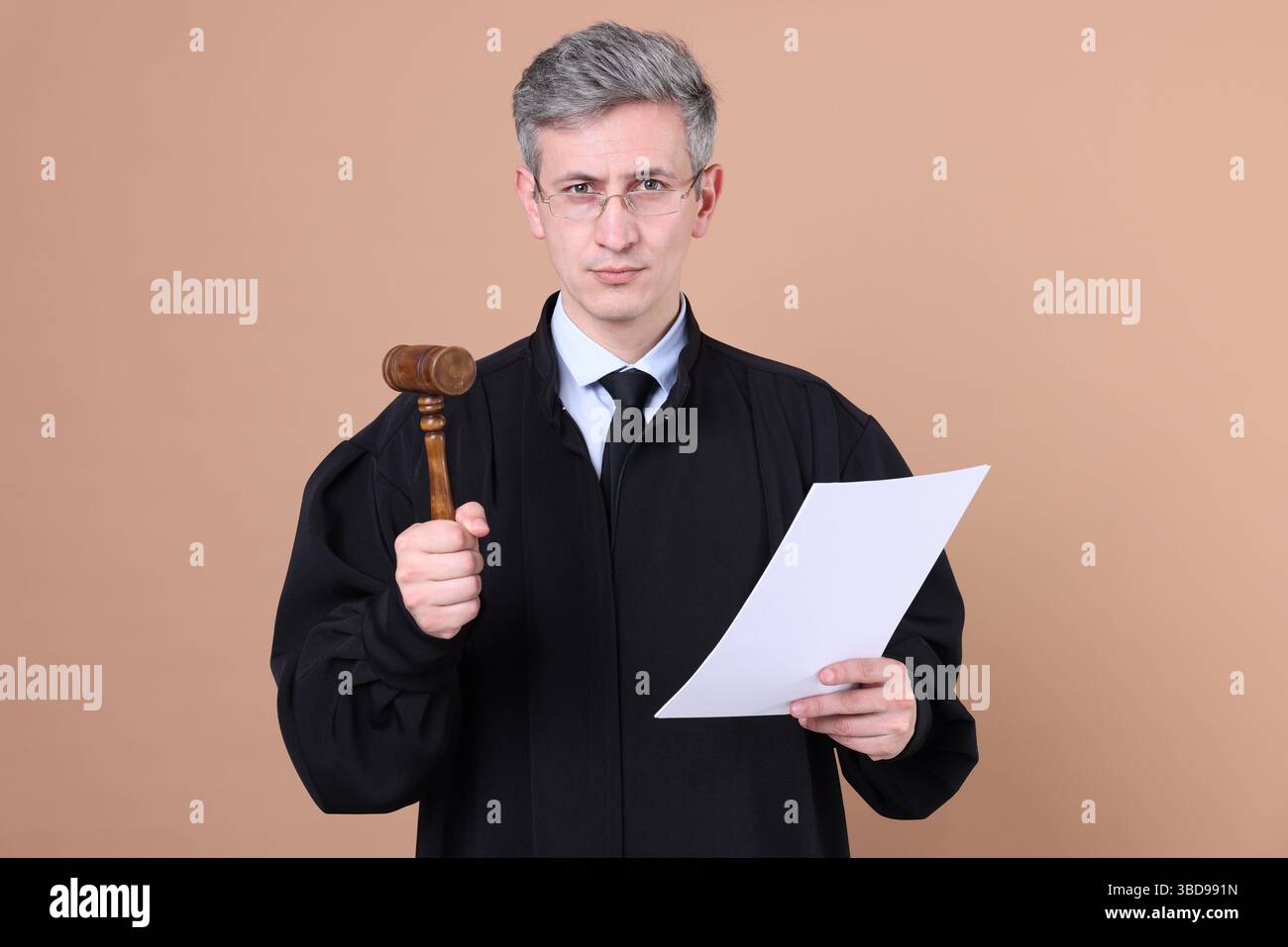 Judge with mallet and document on beige background Stock Photo - Alamy