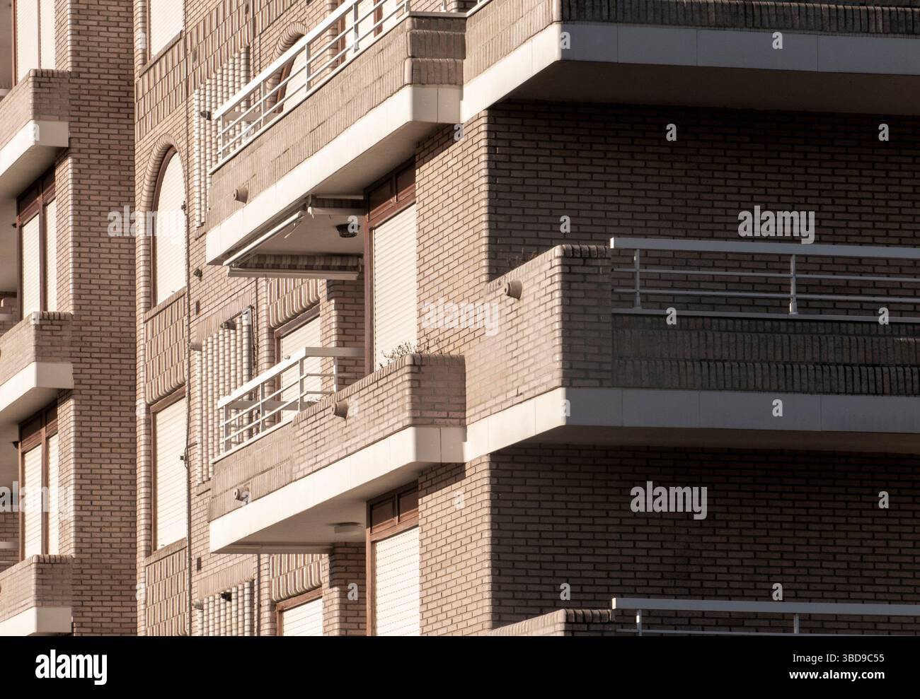 Contemporary brick apartment building featuring multiple balconies ...