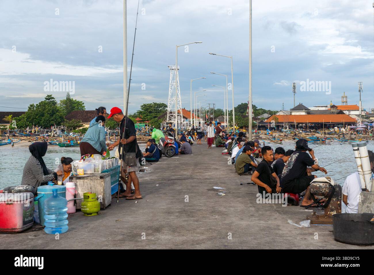 Bali, Indonesia - Dec 22, 2024: Group of people are sitting on the pier ...