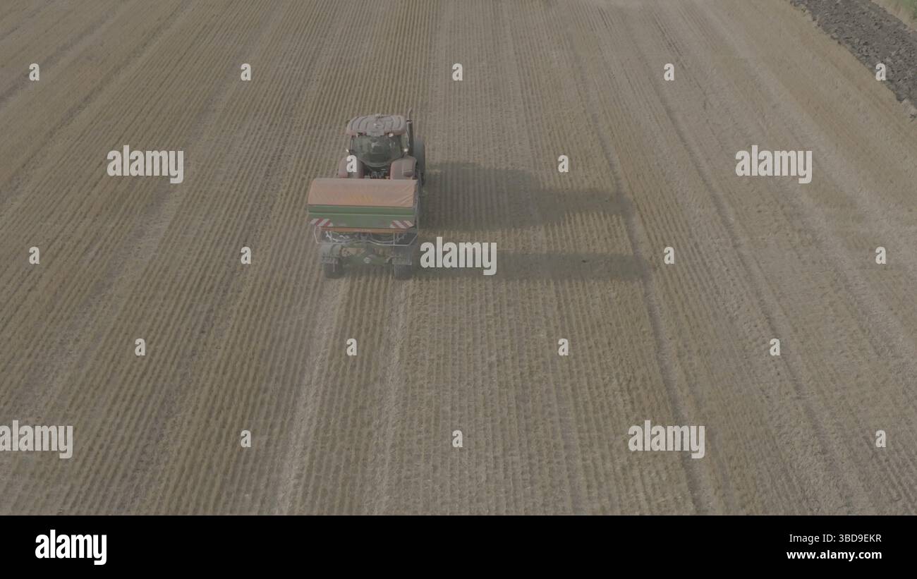 Aerial view of Farmer fertilizing agricultural field. Spreading mineral fertilizer in slow ...
