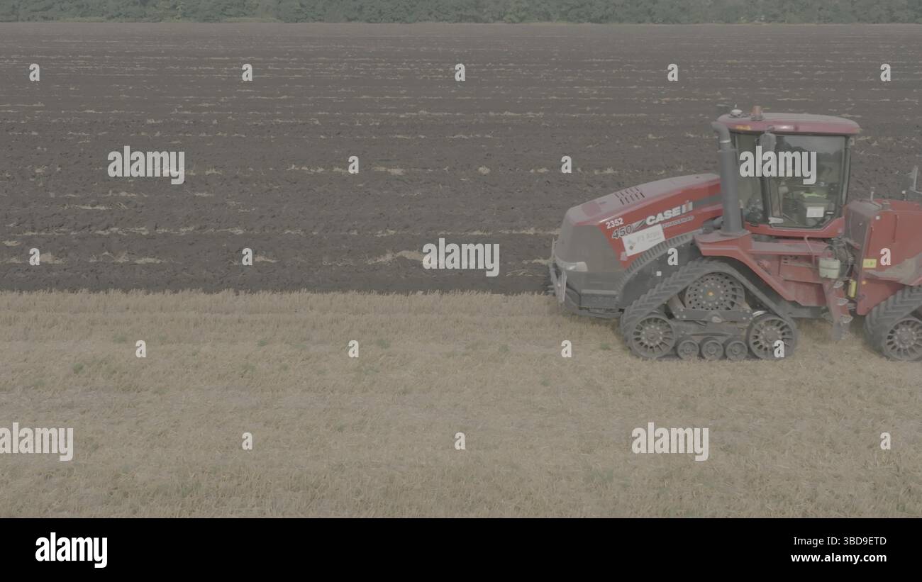 Big red tractor on on rubber tracks, Pulling productive reverse plow on ...