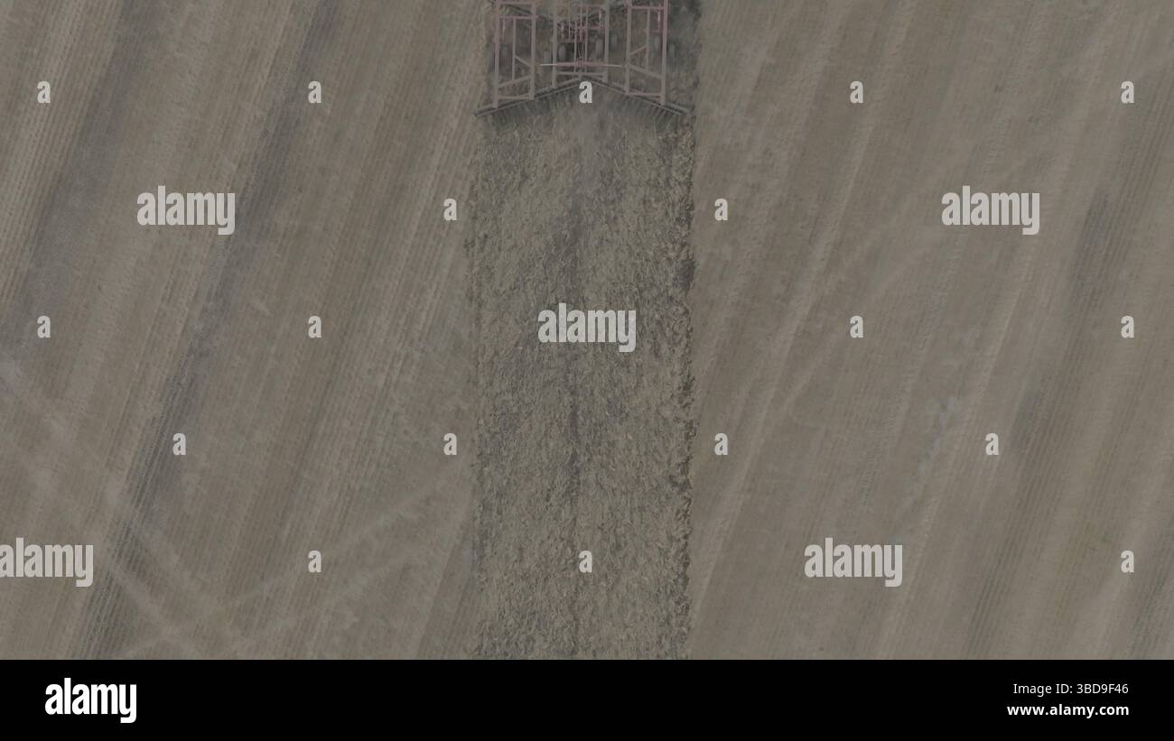 Big red Tractor Pulling Disc Harrow Through Field in Preparation soil ...