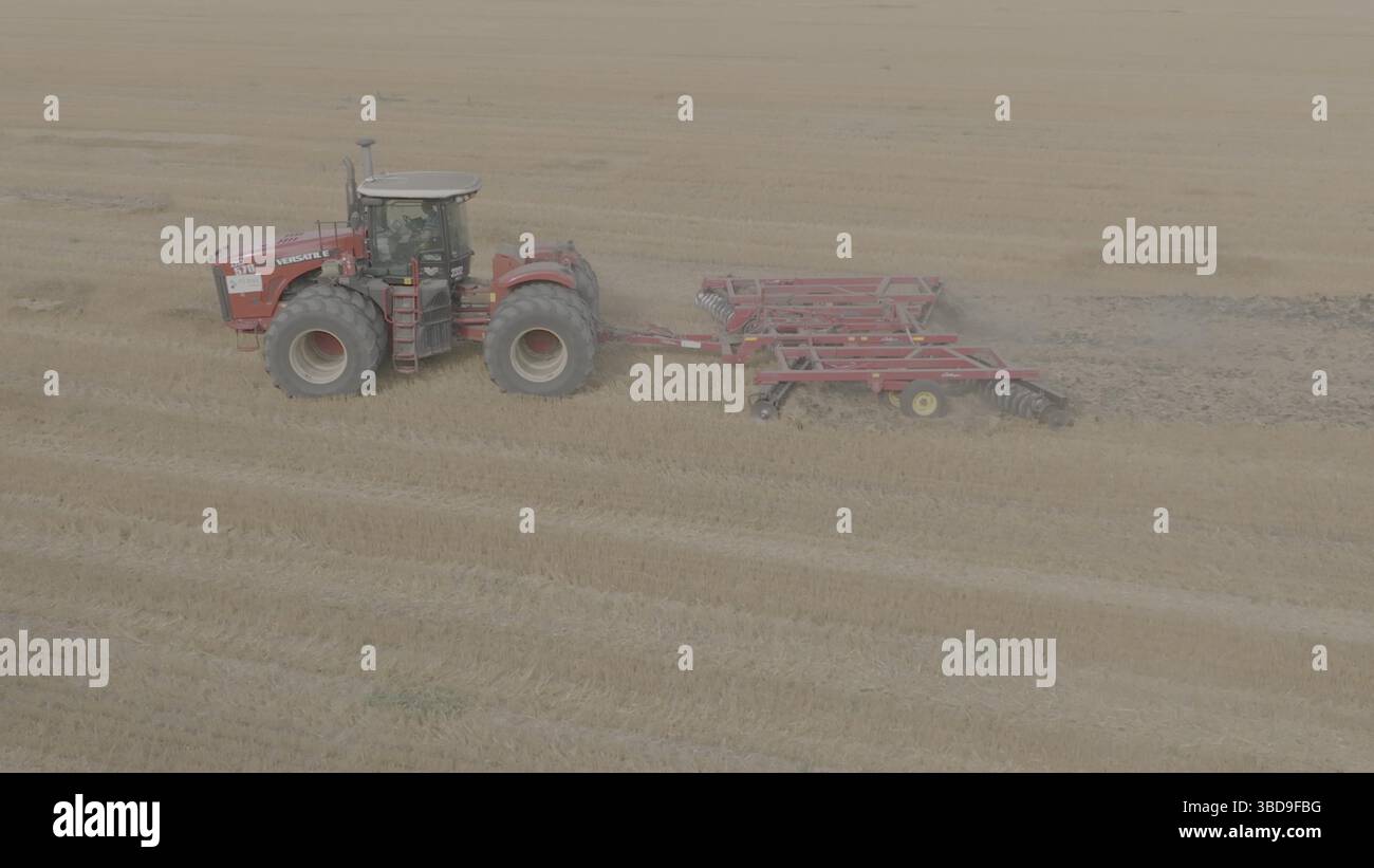Tractor Pulling Disc Harrow Through Field in Preparation soil for ...