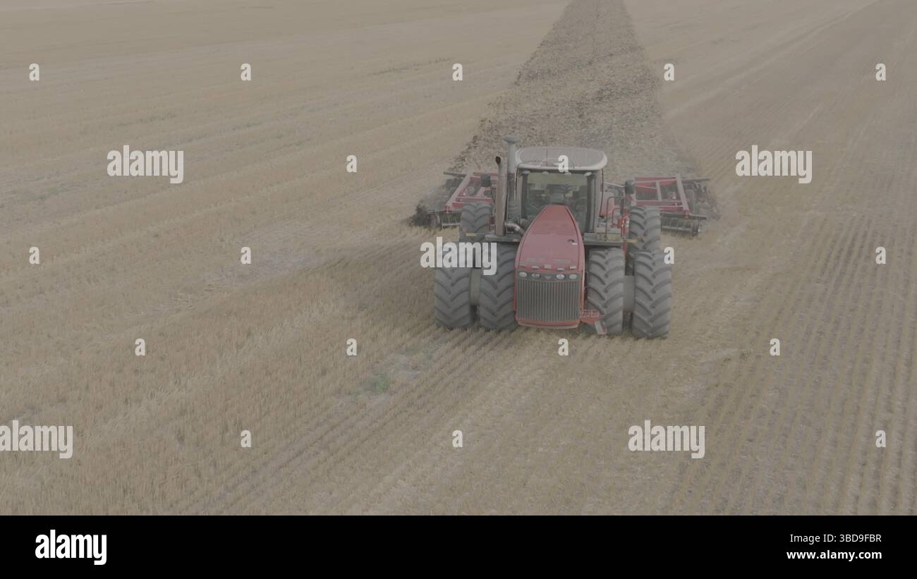 Big red Tractor Pulling Disc Harrow Through Field in Preparation soil ...