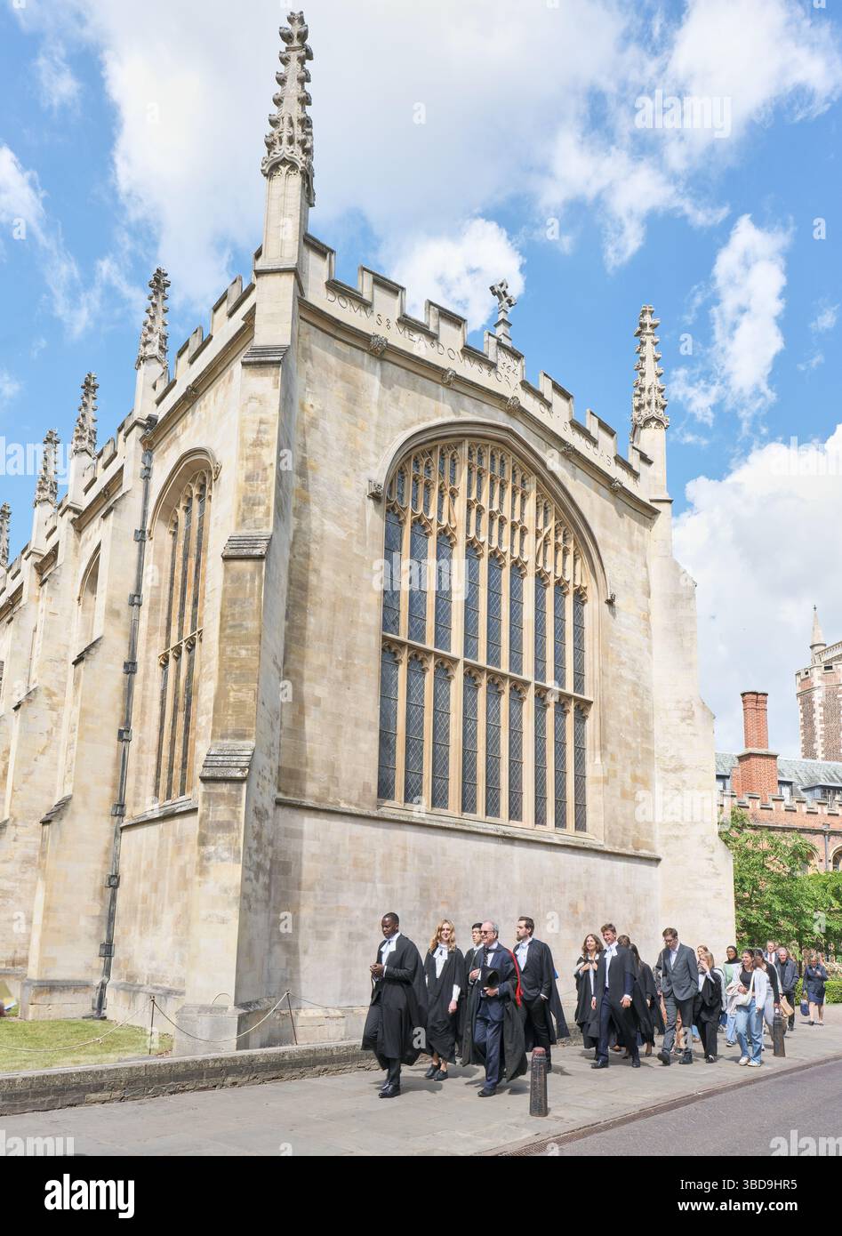 A group of students and friends process past Trinity College chapel on ...
