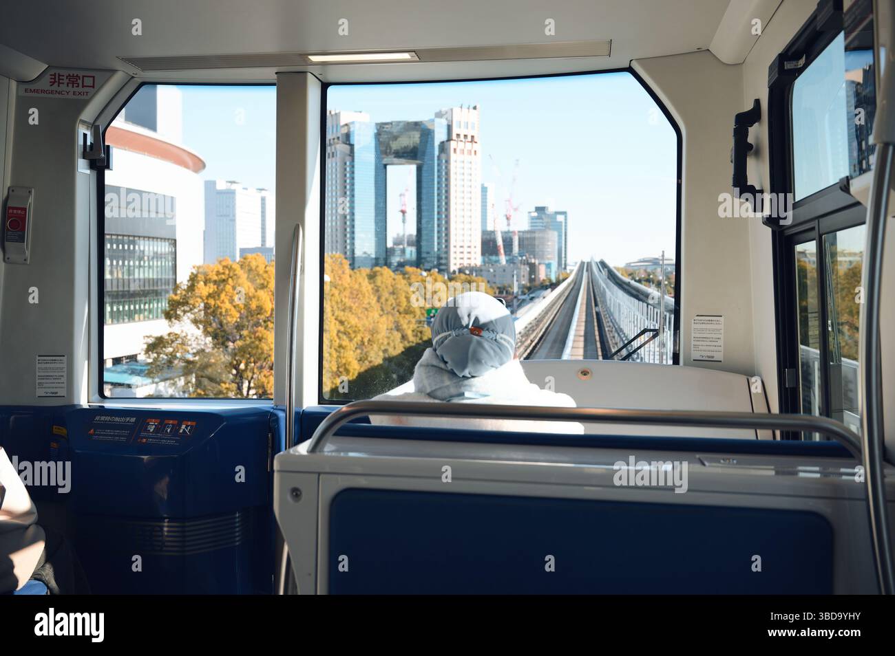 A passenger gazes out the front panoramic window of the Yurikamome line ...