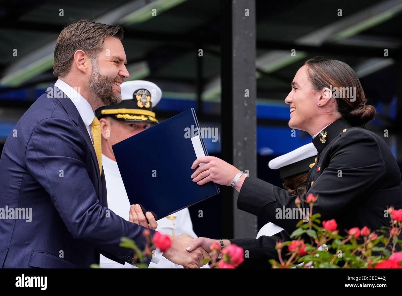 Vice President JD Vance, left, hands a diploma to a graduate during the ...