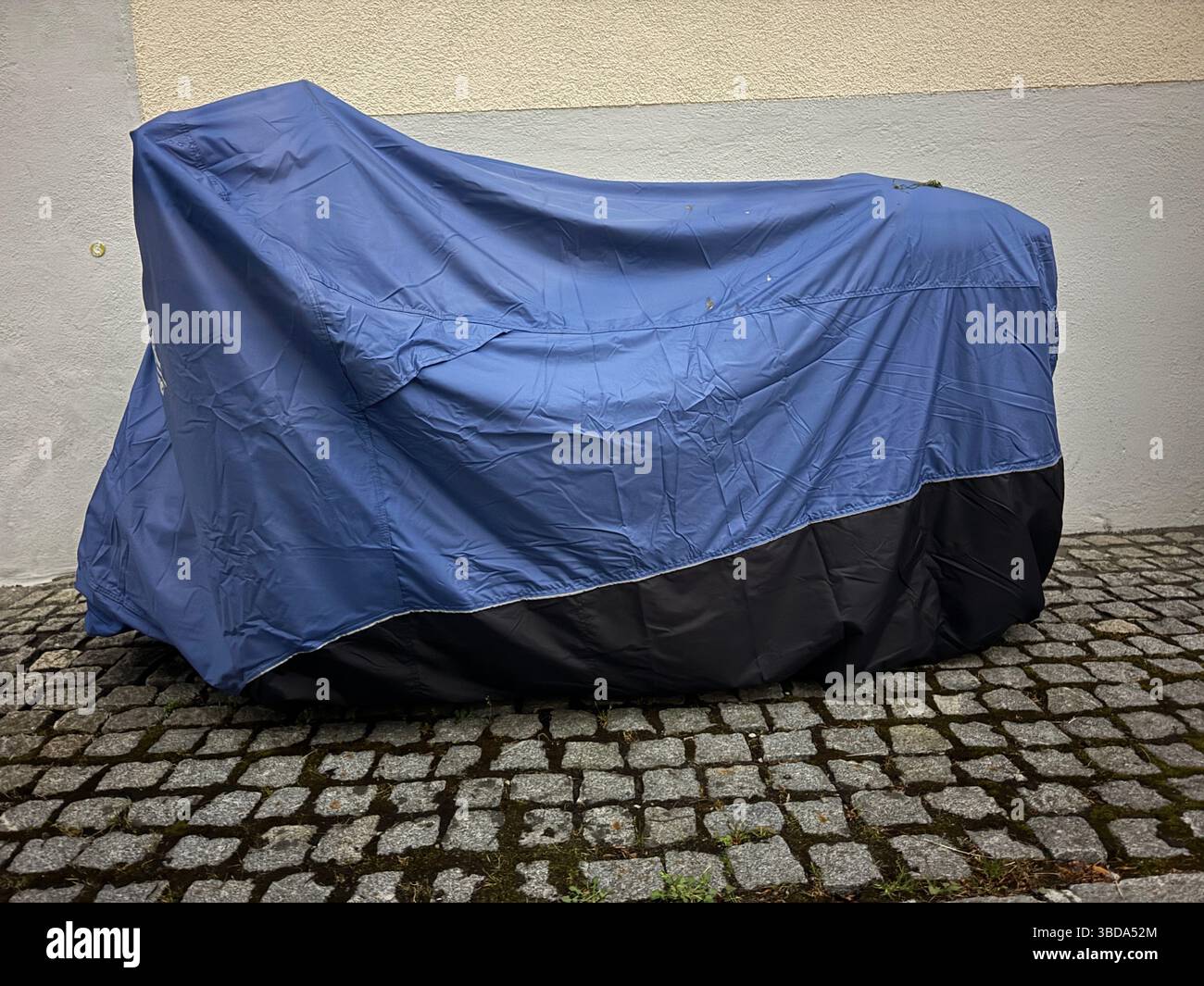 Blue and black motorcycle cover is draped over a motorcycle Stock Photo ...