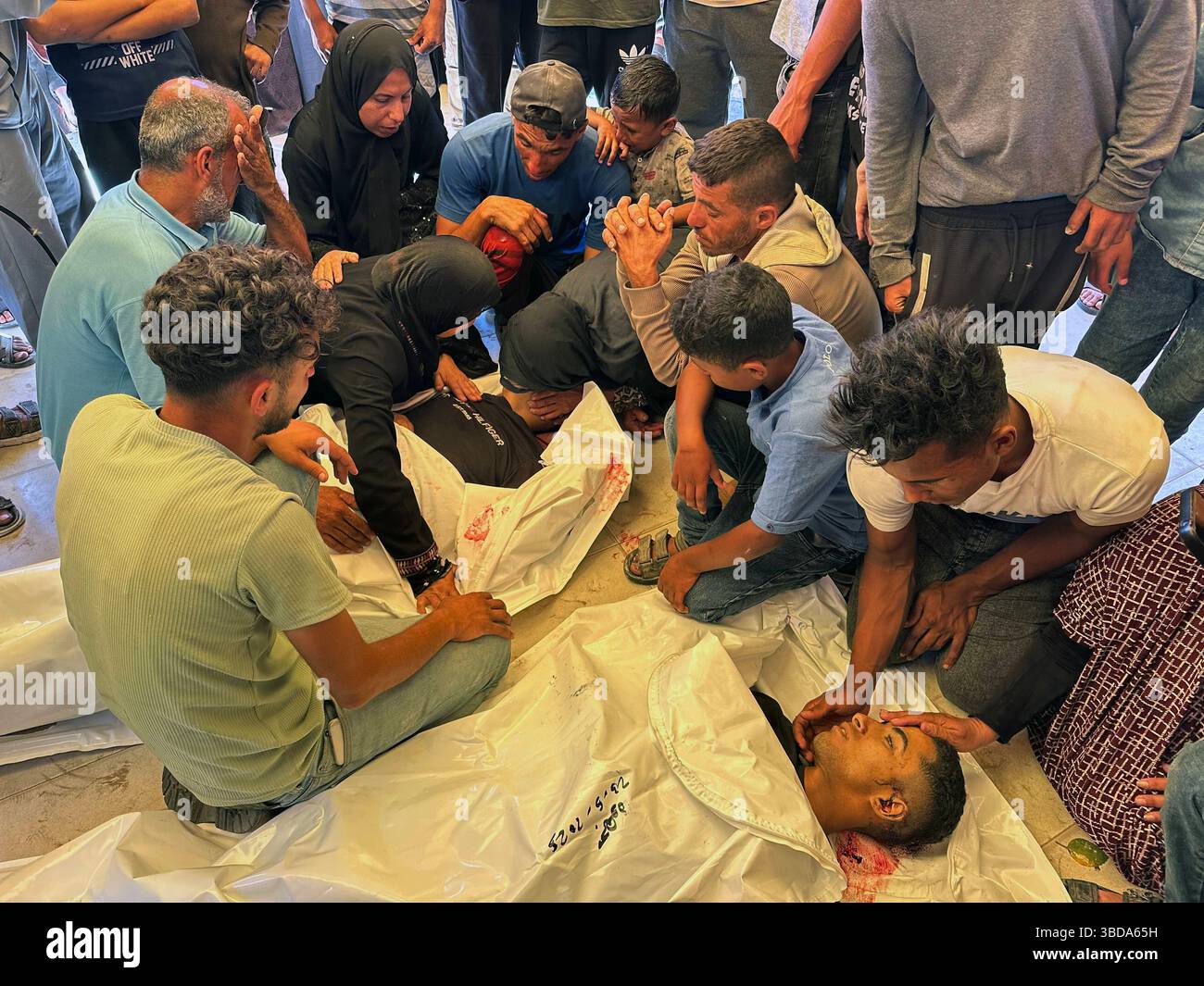 Bodies of Palestinians, who lost their lives in Israeli attacks, are received by their relatives ...