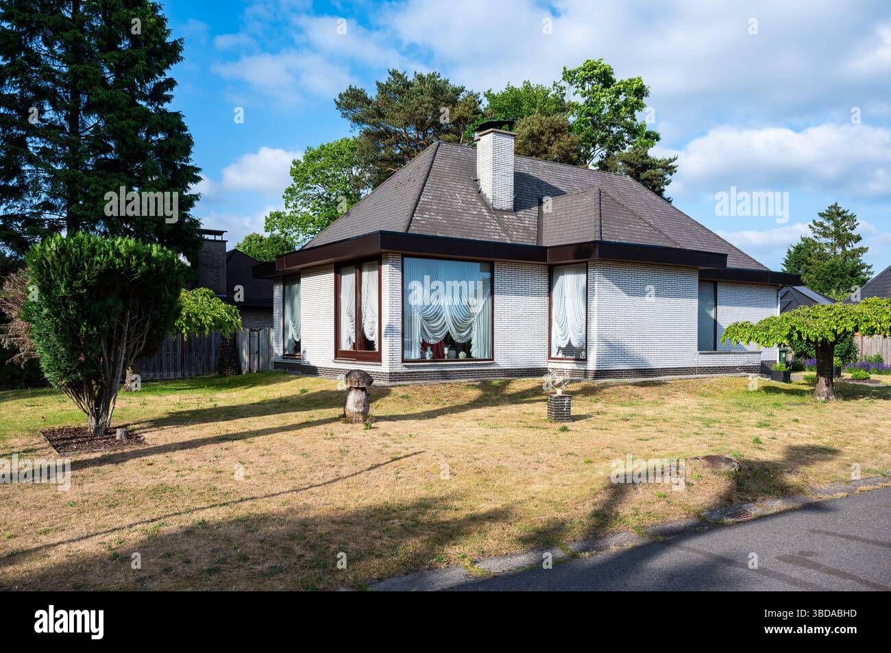 Stand alone house and front yard with dried out grass meadow in Putte ...