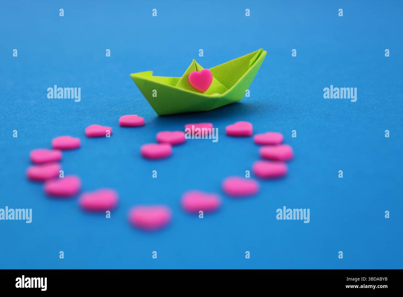 Green paper boat leaving a heart-shaped wake Stock Photo - Alamy