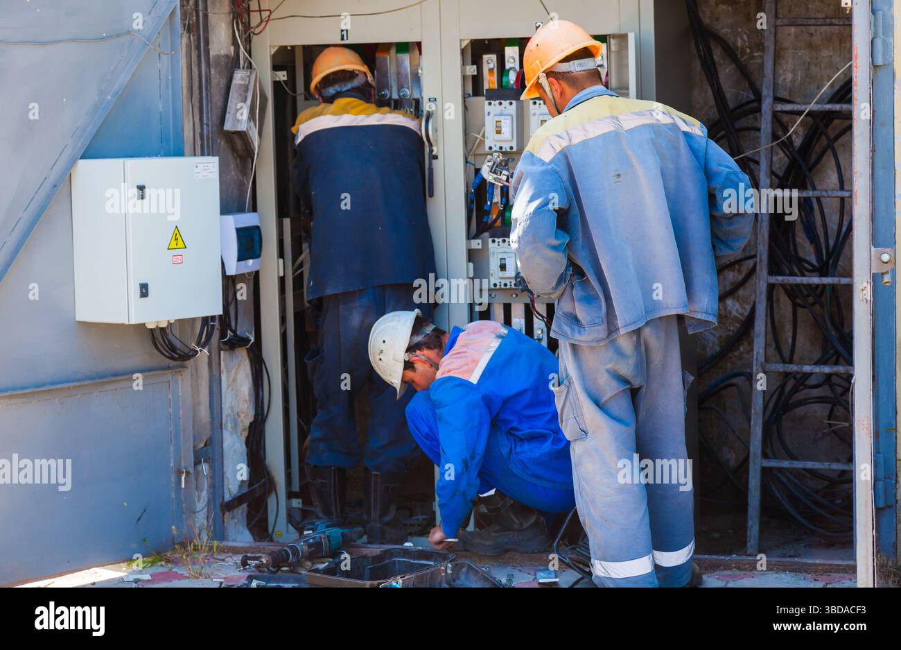 Electrician workers are making repairs in the electrical panel room ...