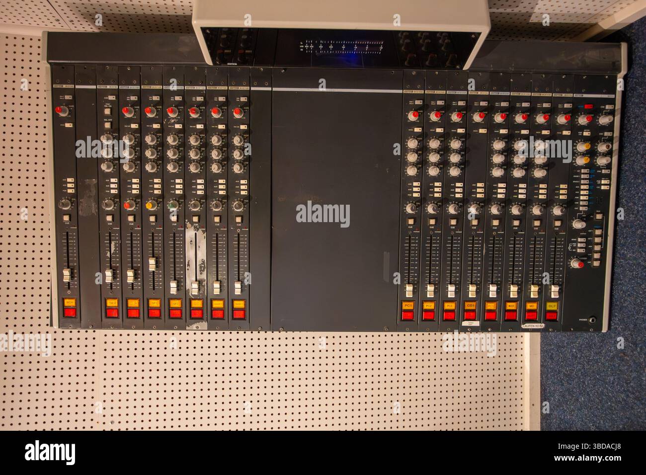 A professional sound mixing console is set up in a recording studio ...