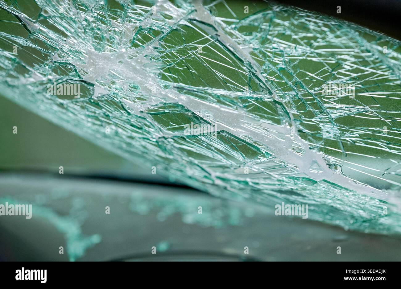 Fractured car windshield showing impact center and radiating lines ...