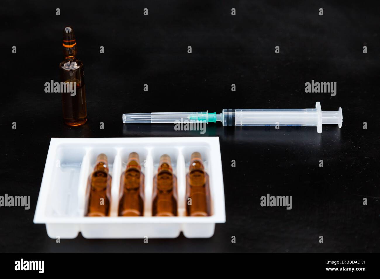 Syringe with needle and ampoules for injection on a black background ...