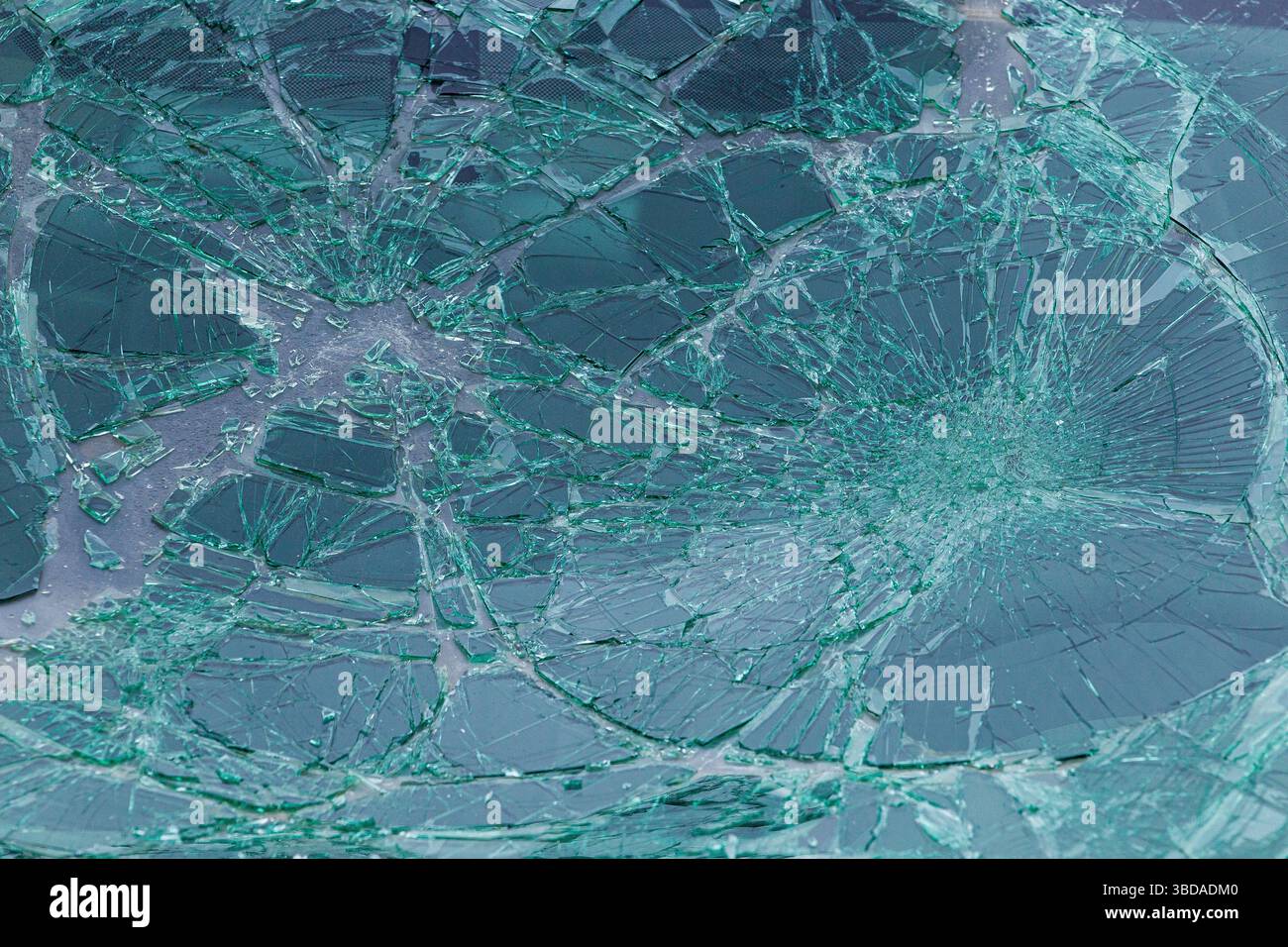 Close-up of shattered green safety glass with intricate cracks. Broken ...